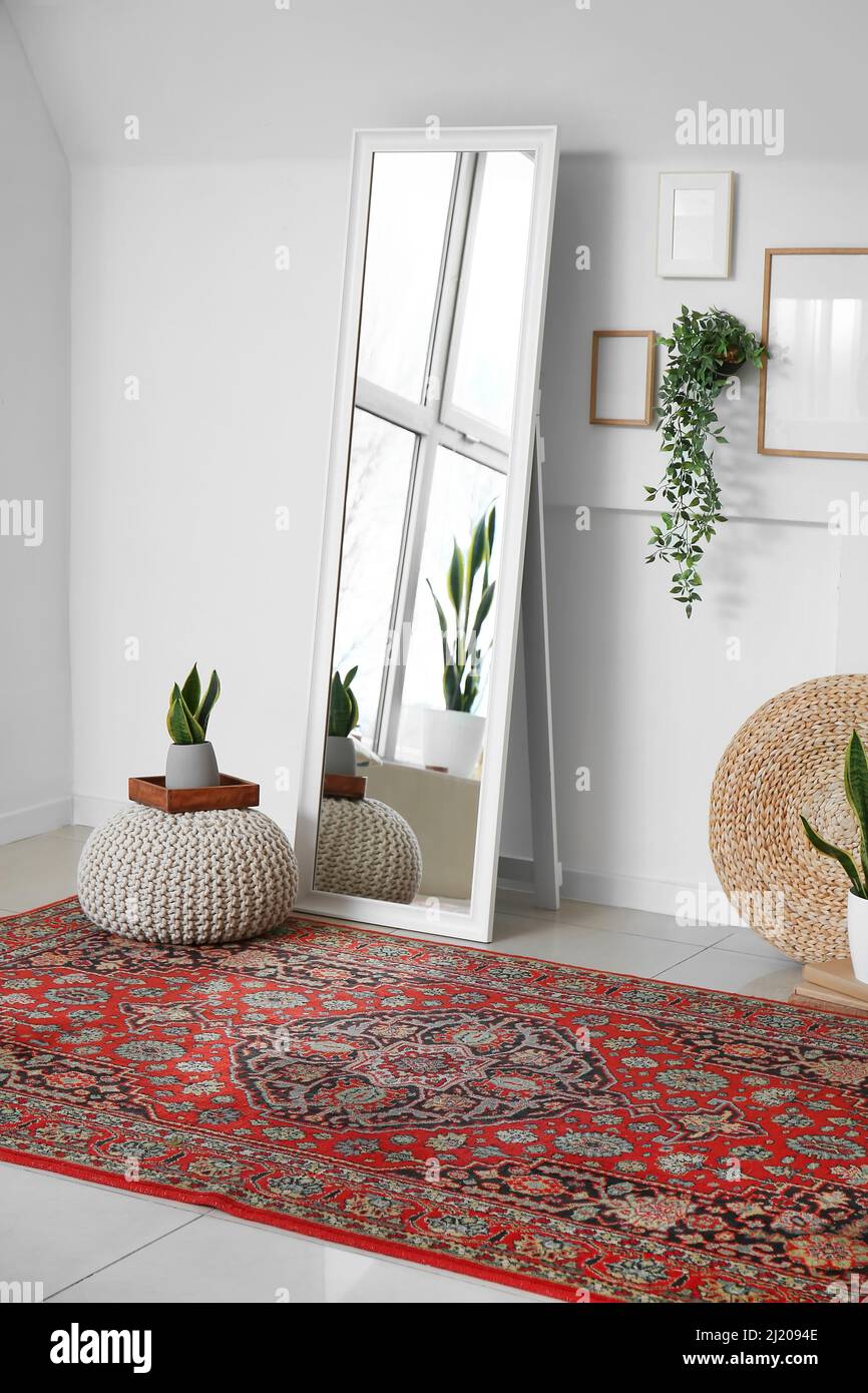 Interior of cozy living room with mirror, poufs and vintage carpet ...