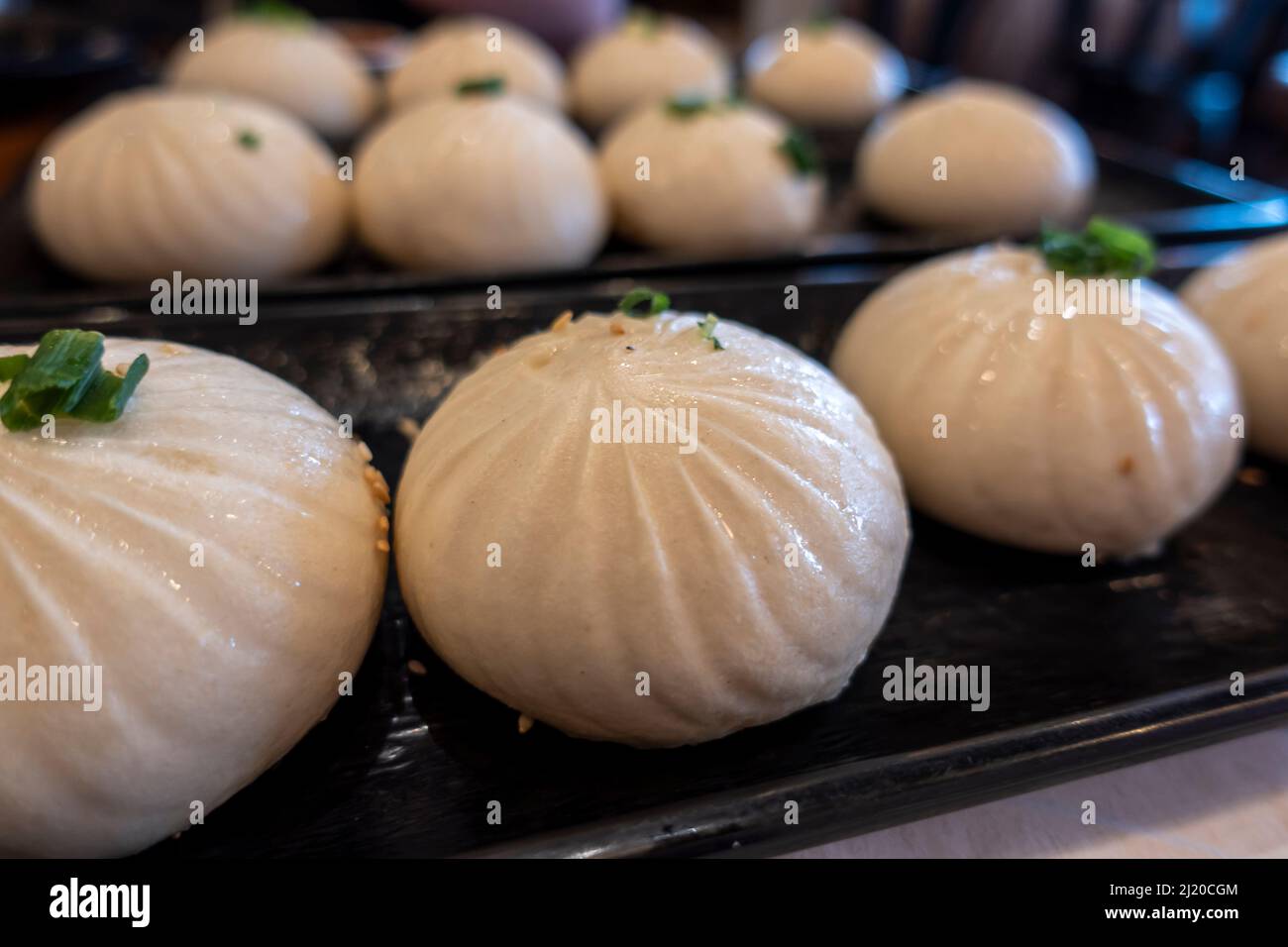 Close up view of xiao long bao in a steamer basket inside a restaurant ...