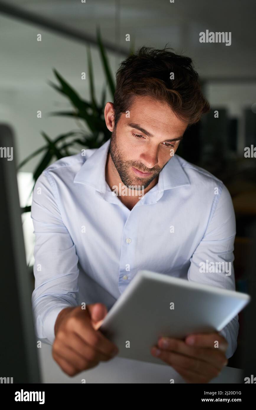 Putting in the hours to achieve success. Shot of a young businessman ...