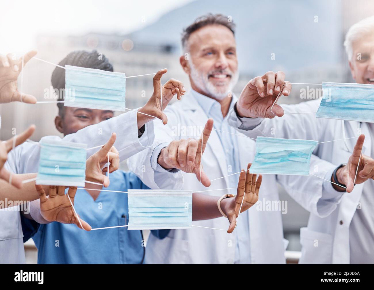 All you have to do is wear a mask. Shot of a group of doctors holding ...