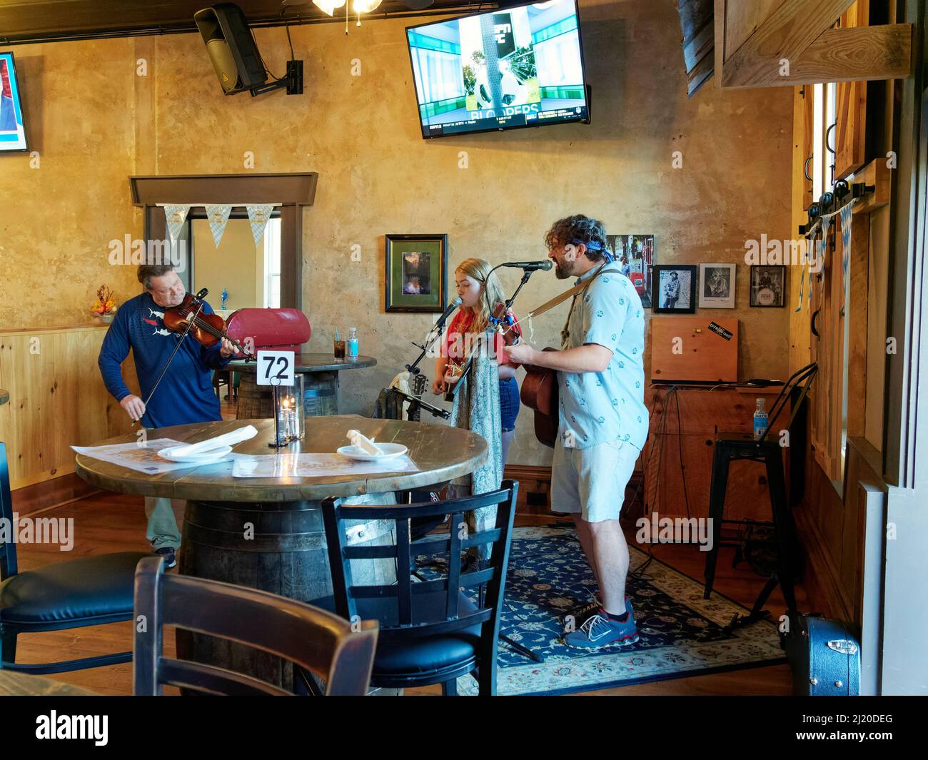 Musicians in a band playing guitar and singing in a restaurant in ...