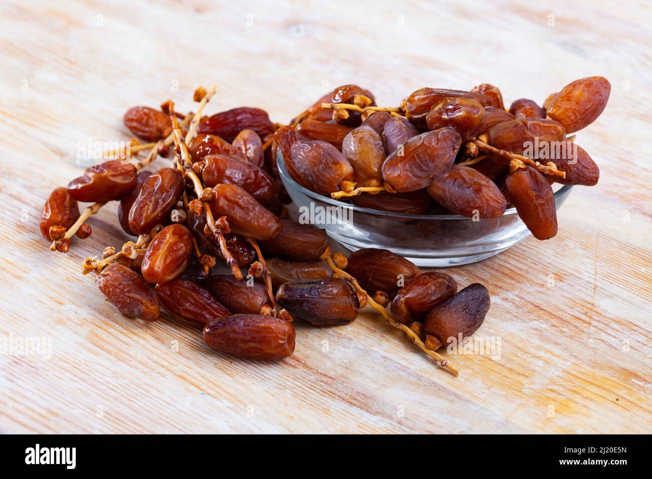 Dried dates in plate on wooden background Stock Photo - Alamy