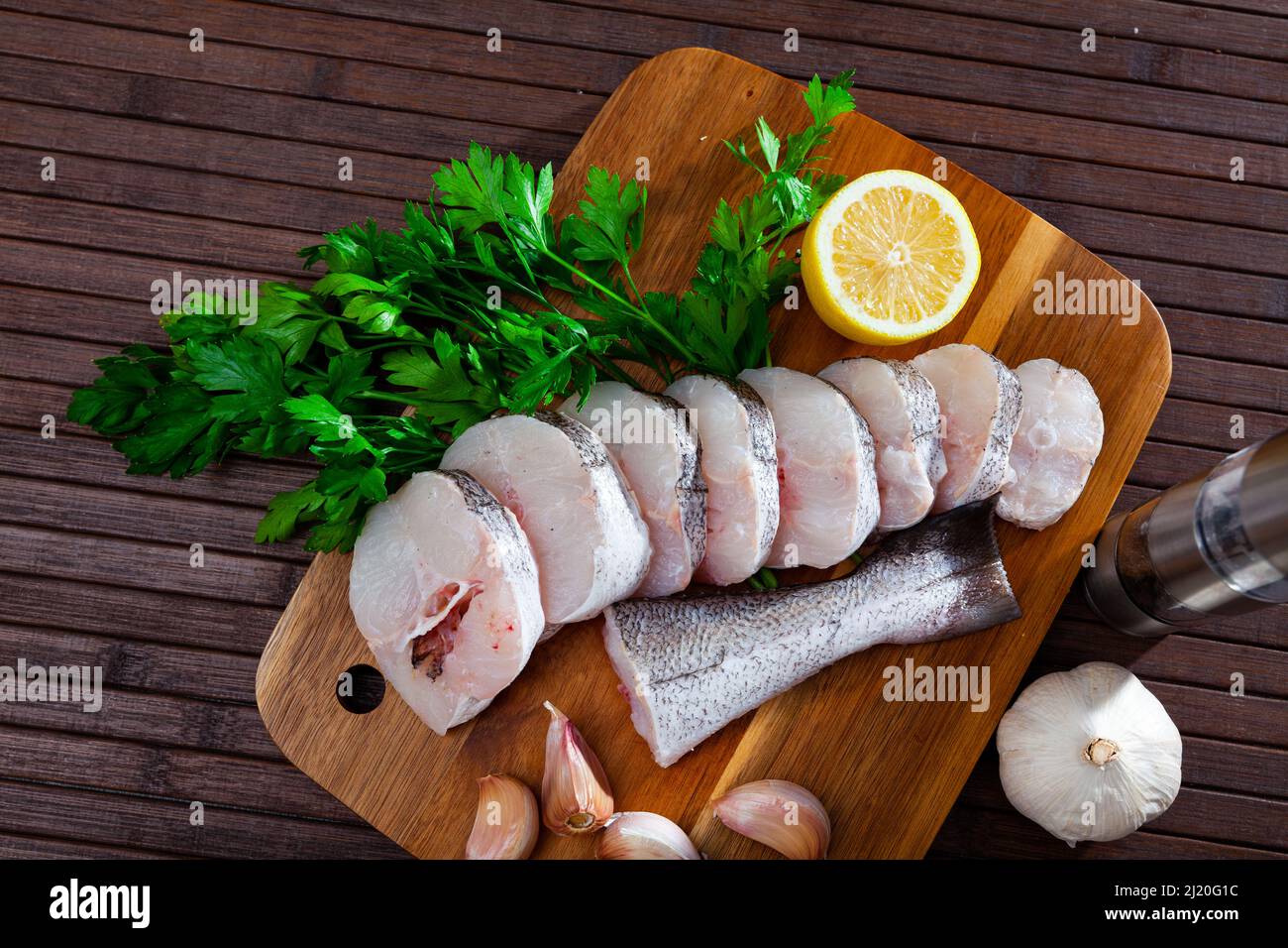 Raw steaks of hake with lemon and greens ready for cooking Stock Photo ...