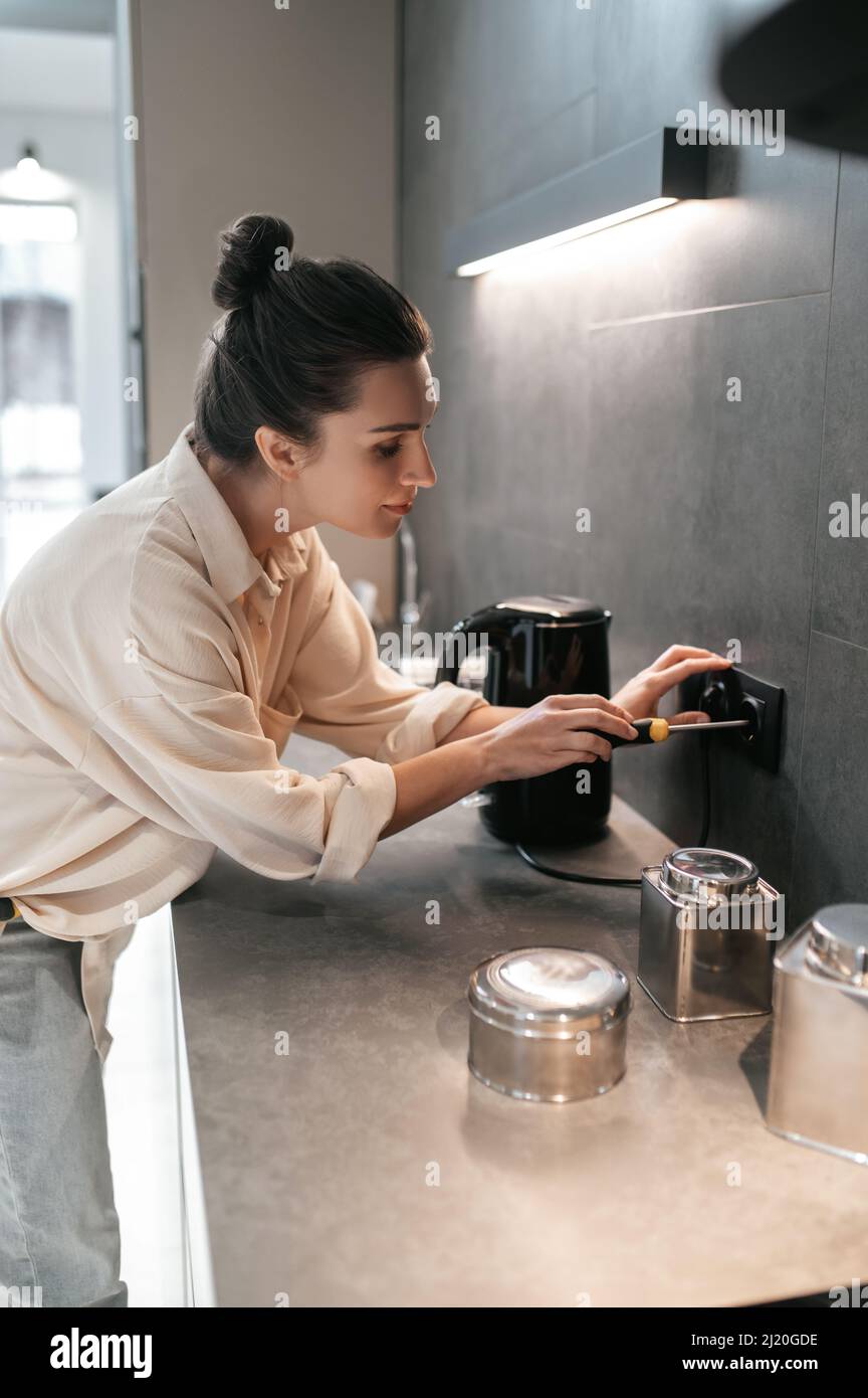A housewife doing repair works in the kitchen Stock Photo - Alamy