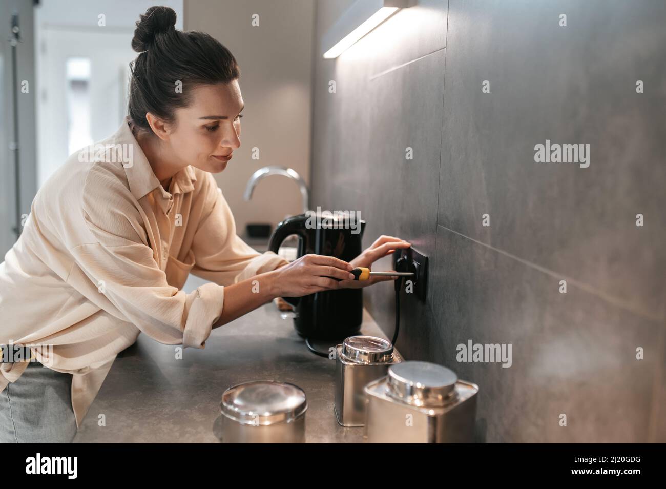 A housewife doing repair works in the kitchen Stock Photo - Alamy