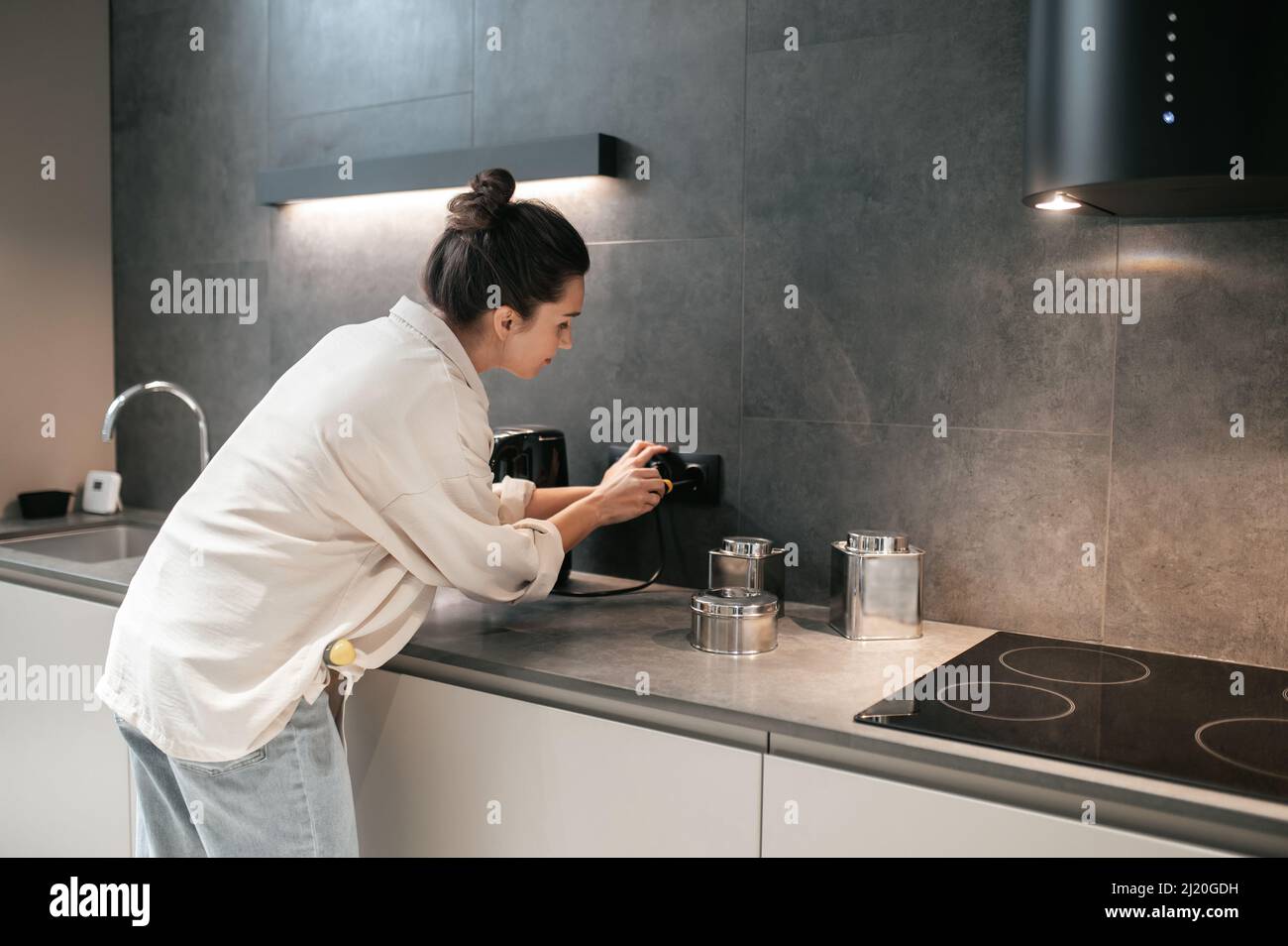 A housewife doing repair works in the kitchen Stock Photo - Alamy