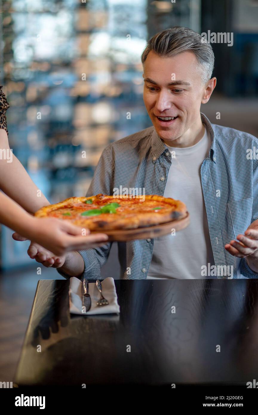 A man eating pizza and looking excited Stock Photo - Alamy