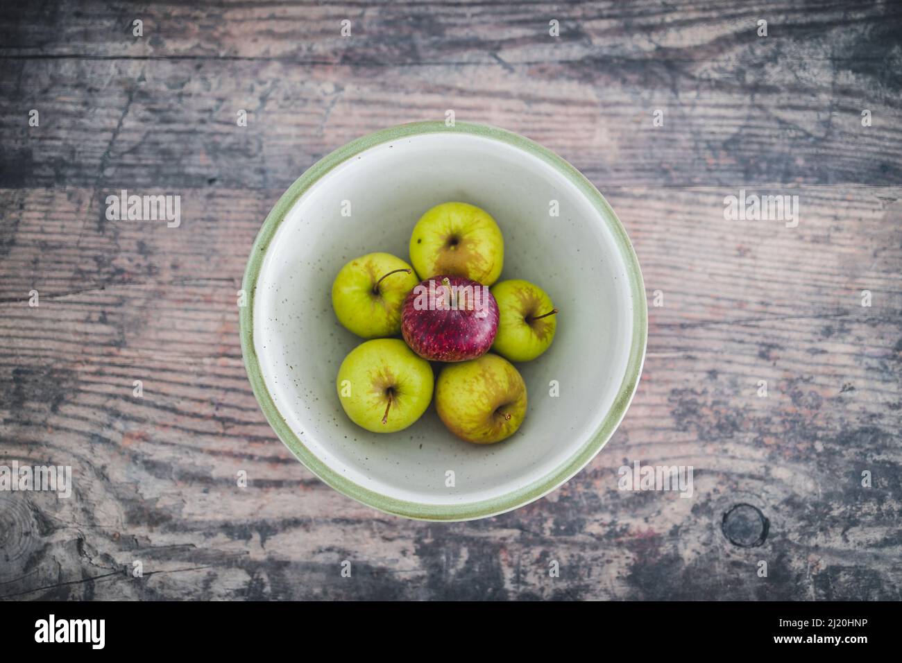 group of green apples with one red apple in the middle, concept of ...