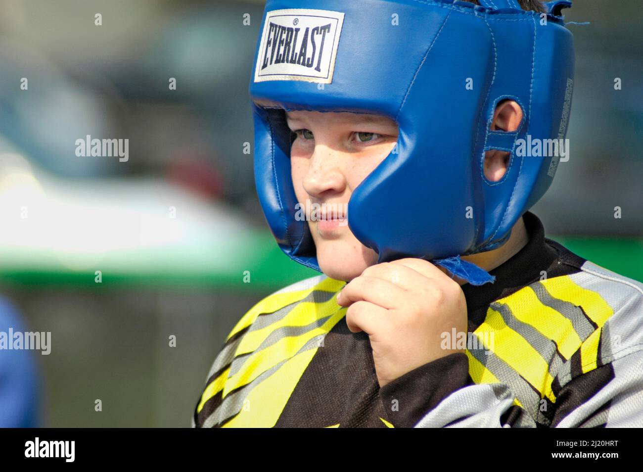 Boy with boxing head gear on for protections from hits and shots to the ...