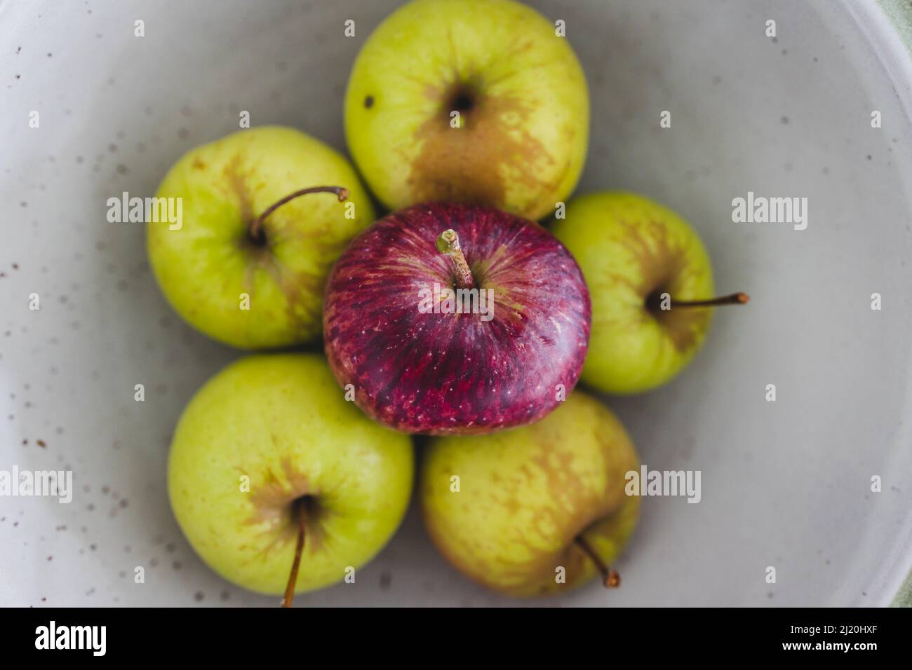 group of green apples with one red apple in the middle, concept of ...