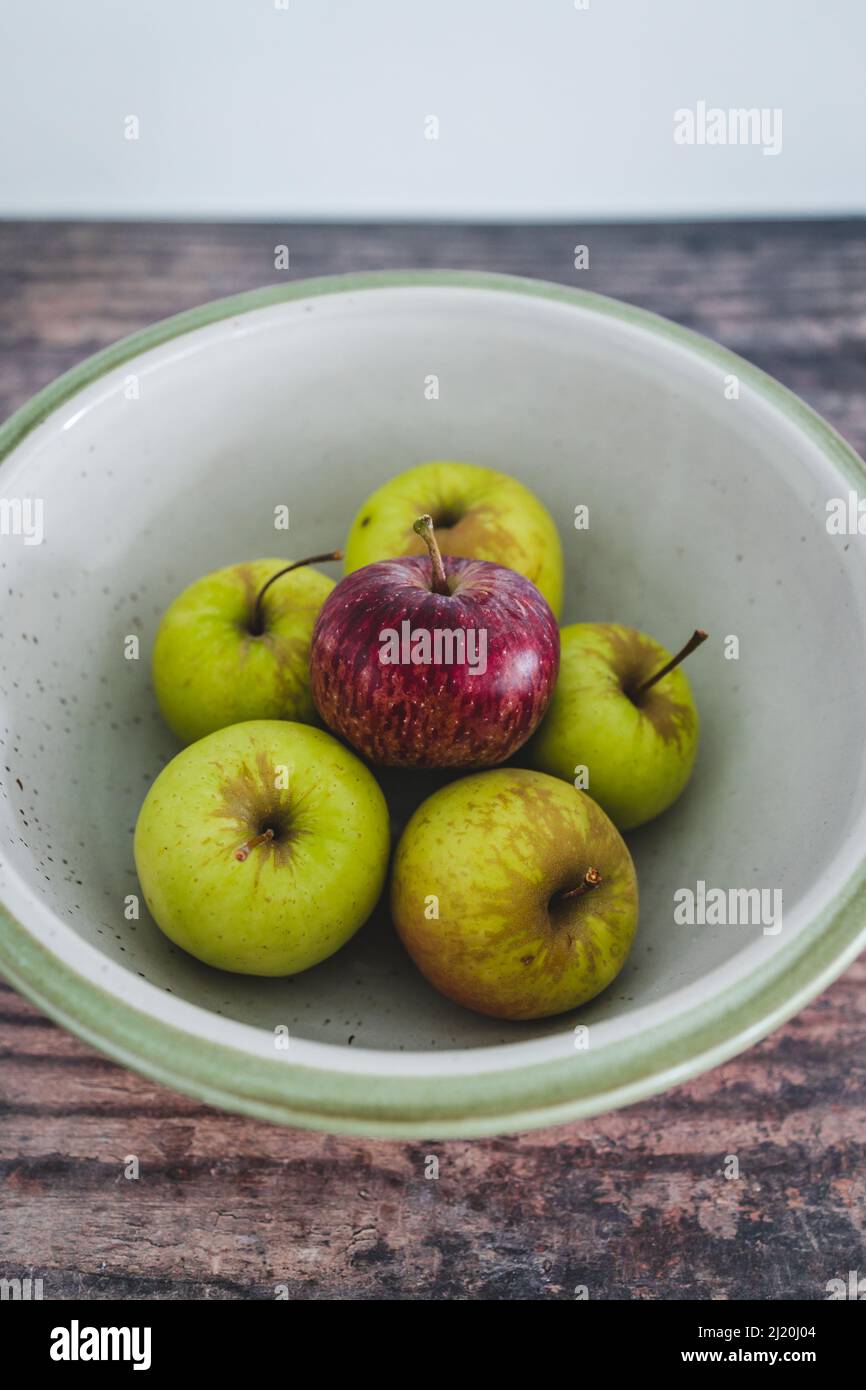 group of green apples with one red apple in the middle, concept of ...