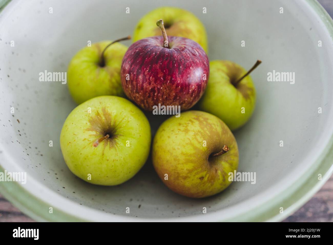 group of green apples with one red apple in the middle, concept of ...