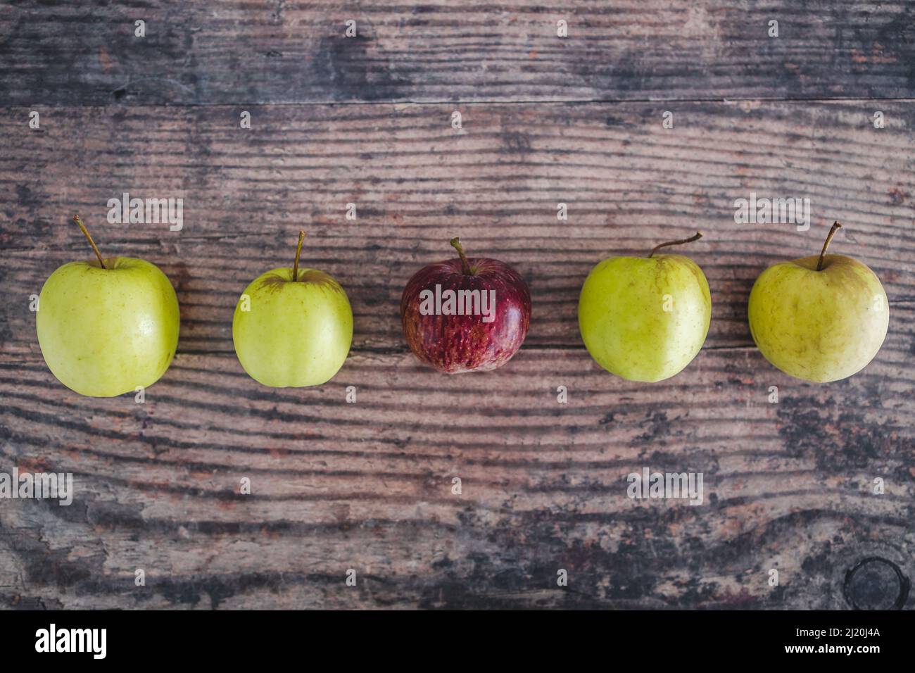group of green apples with one red apple in the middle, concept of ...