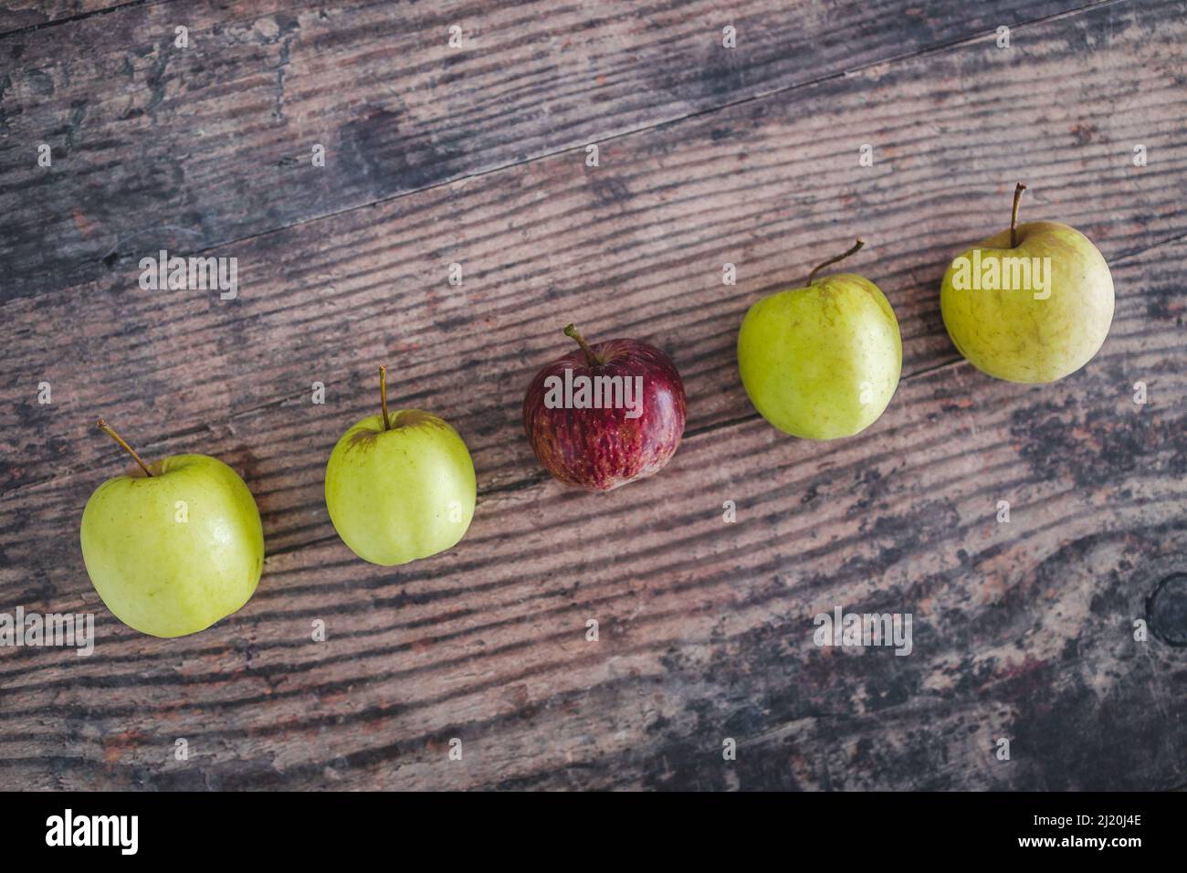 group of green apples with one red apple in the middle, concept of ...