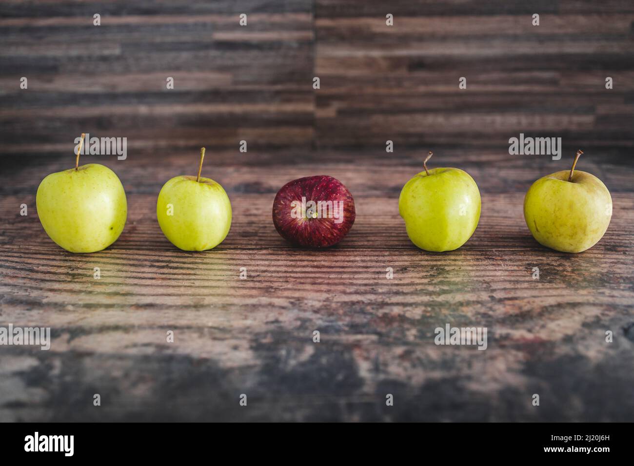 group of green apples with one red apple in the middle, concept of ...