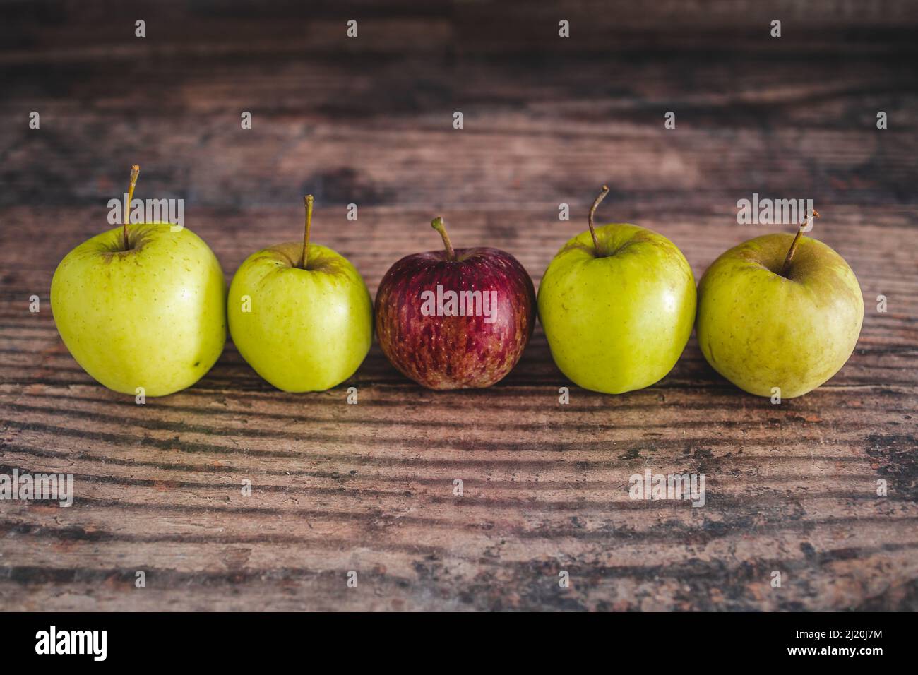 group of green apples with one red apple in the middle, concept of ...