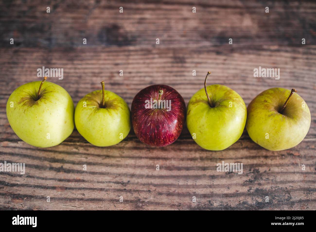 group of green apples with one red apple in the middle, concept of ...