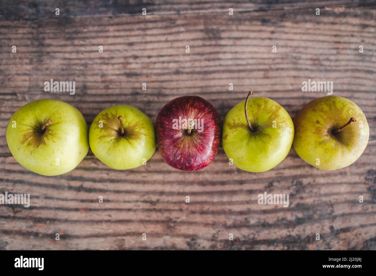 group of green apples with one red apple in the middle, concept of ...