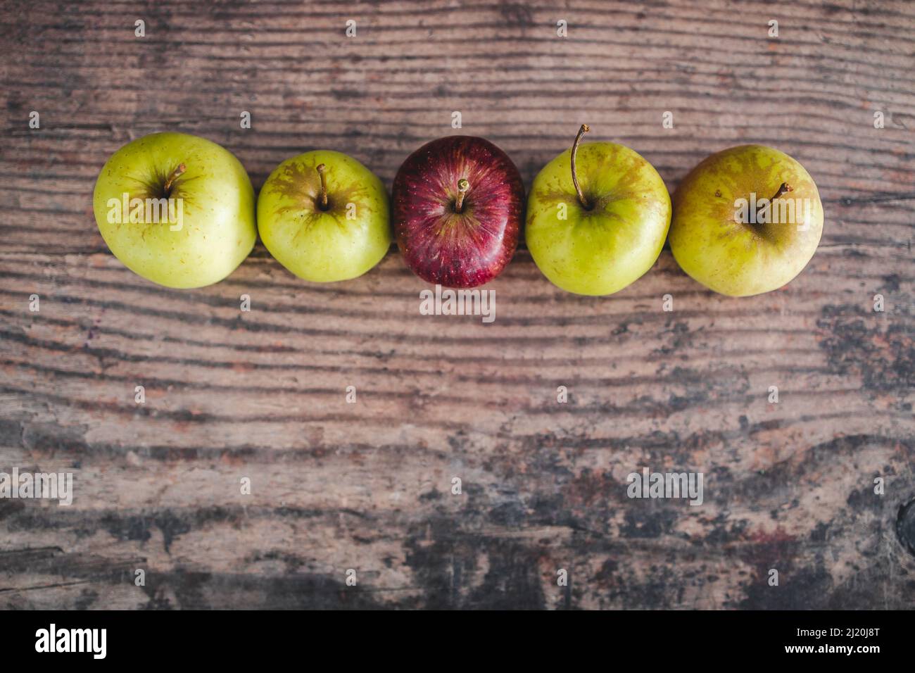 group of green apples with one red apple in the middle, concept of ...