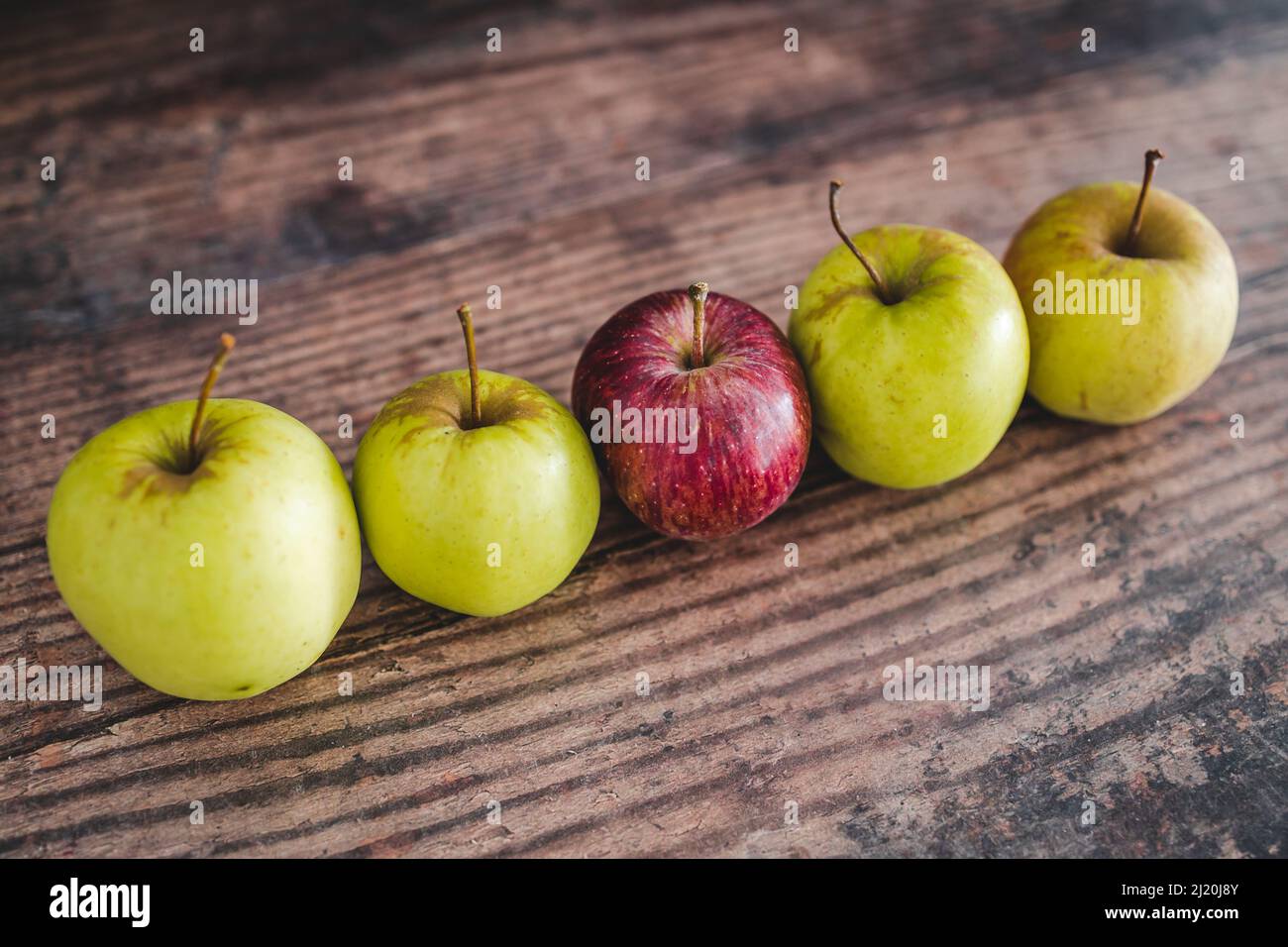 group of green apples with one red apple in the middle, concept of ...