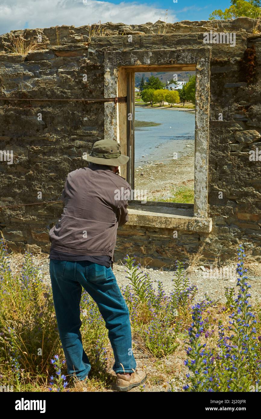Photographer looking through window of derelict building to Lake ...