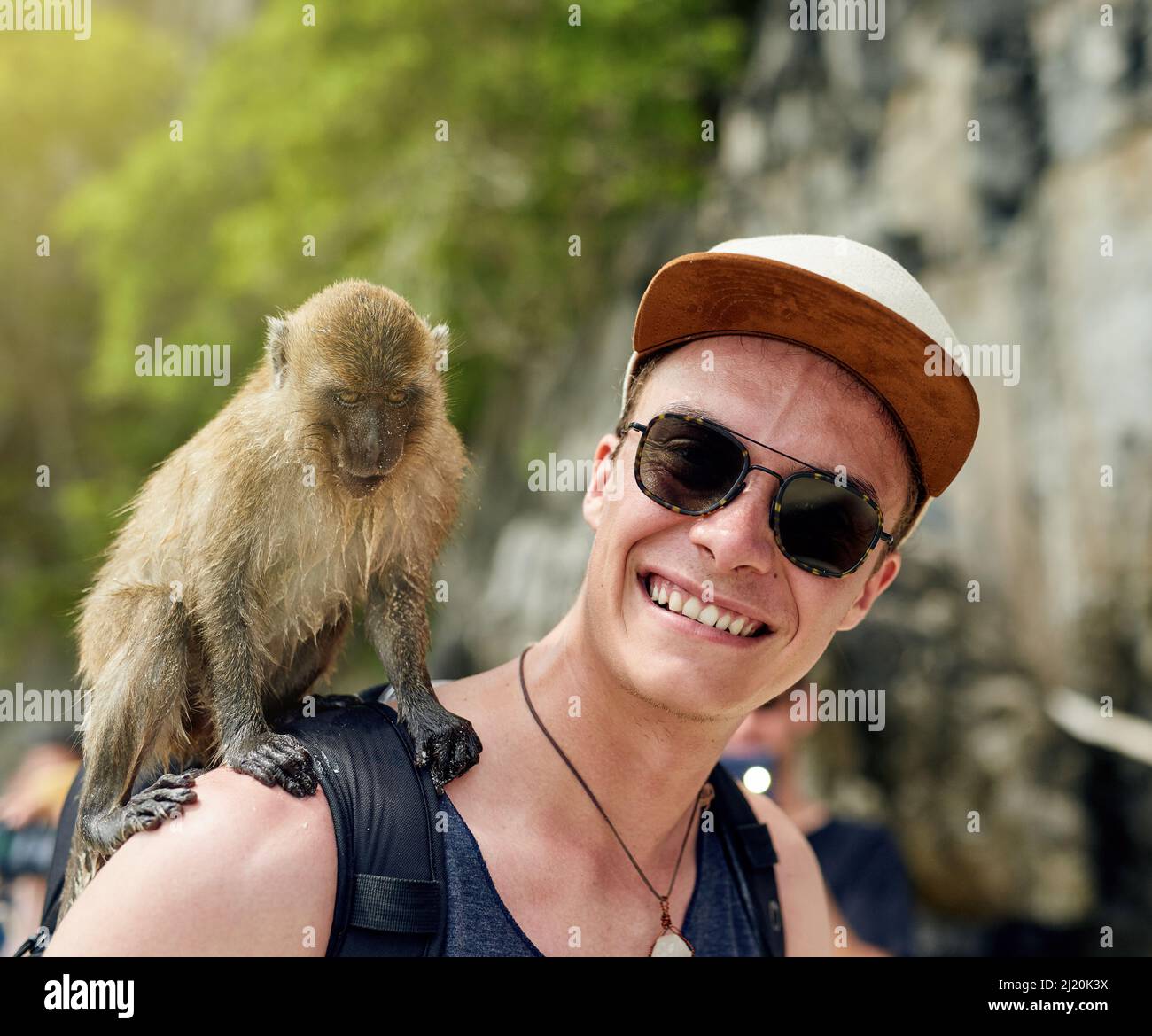 Just monkeying around. Portrait of a young man with a monkey sitting on ...