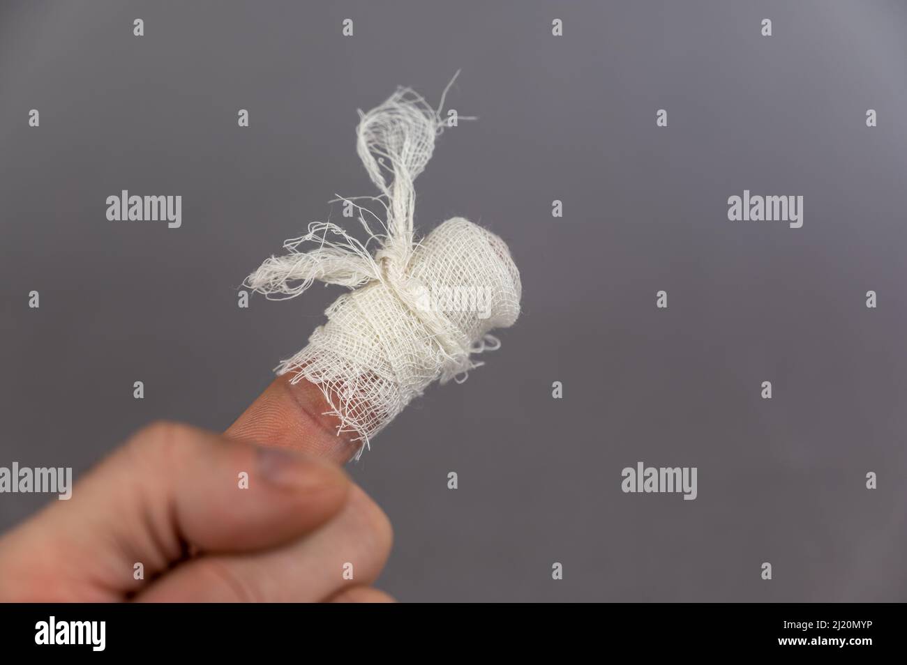The hand of a mature man with a bandaged index finger. The man holds ...