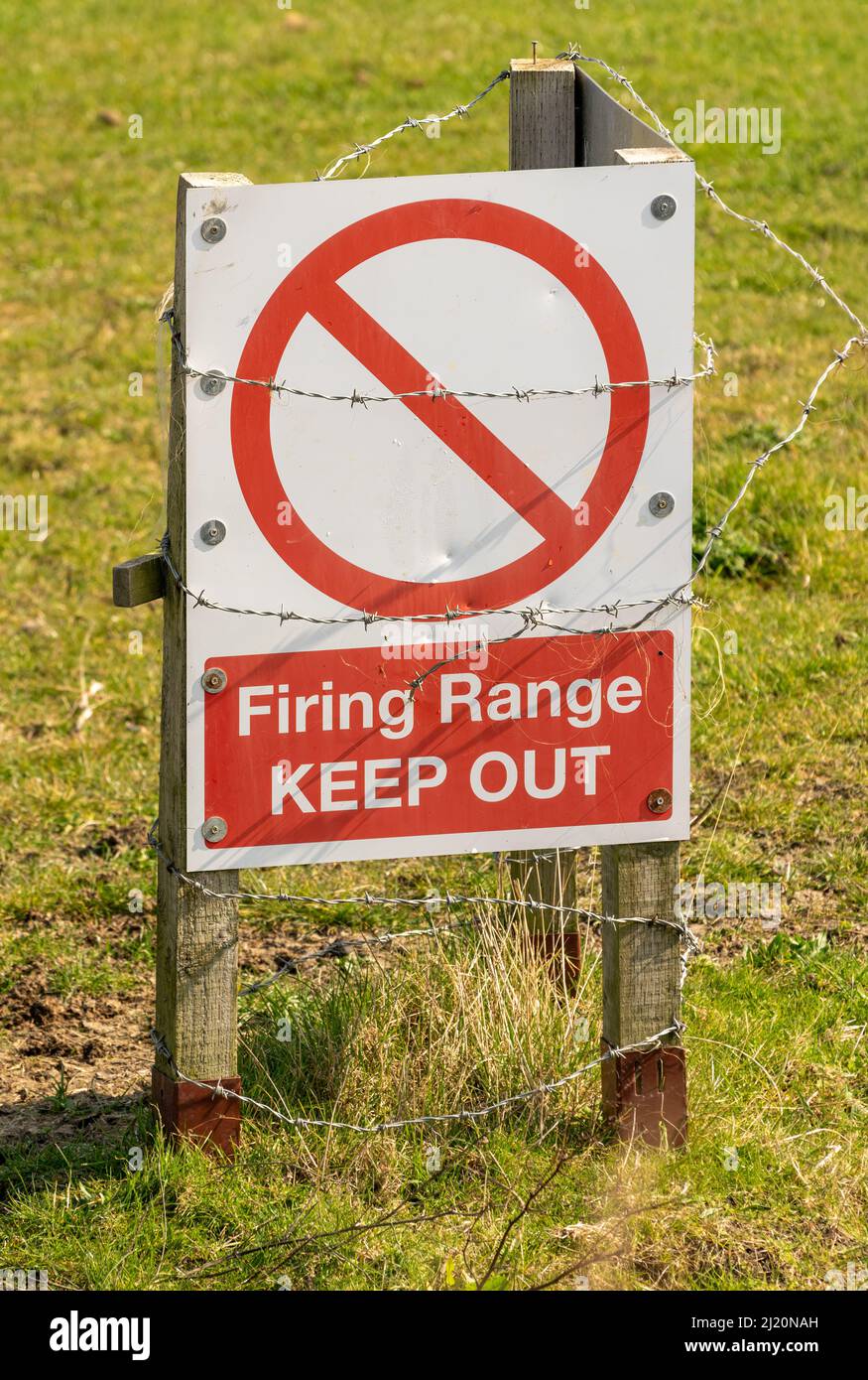 Firing range warning sign wrapped in barbed wire Stock Photo - Alamy