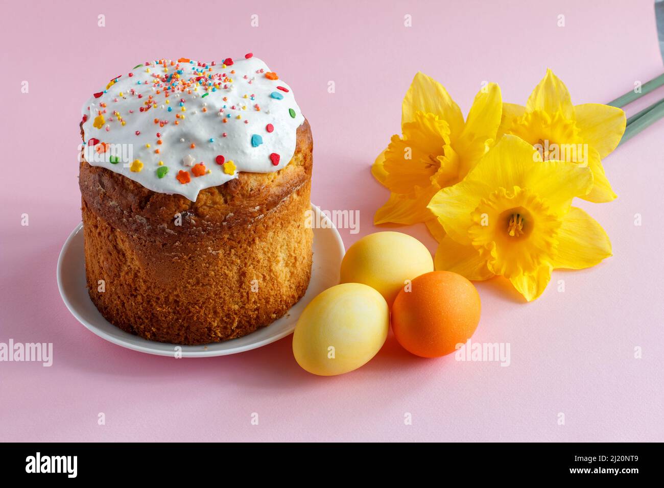 Easter cake and colorful Easter eggs with daffodil flowers. Traditional ...