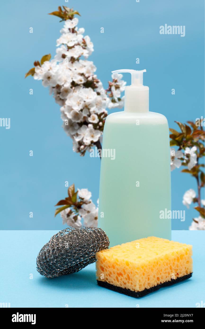 Bottle of dishwashing liquid and sponges with a cherry tree in blossom ...