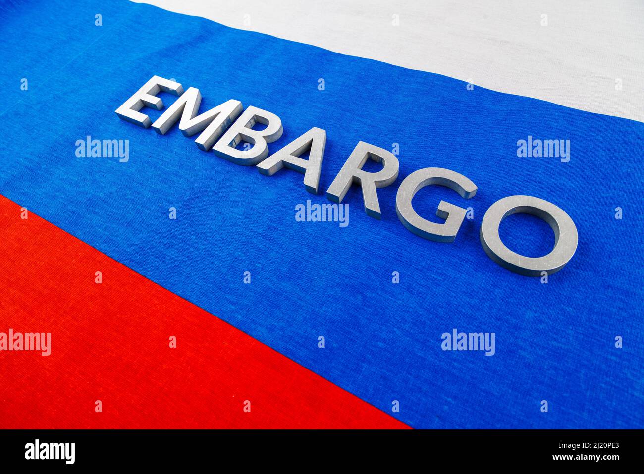 the word embargo laid with silver metal letters on russian tricolor ...