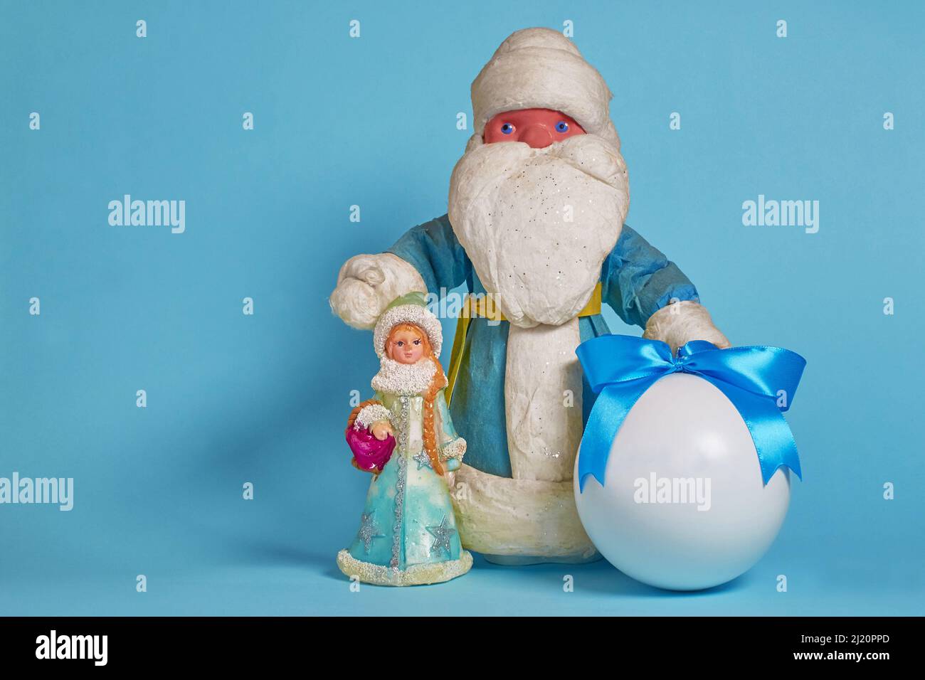 A toy Russian Snow Maiden and Ded Moroz holding a Christmas ball Stock ...