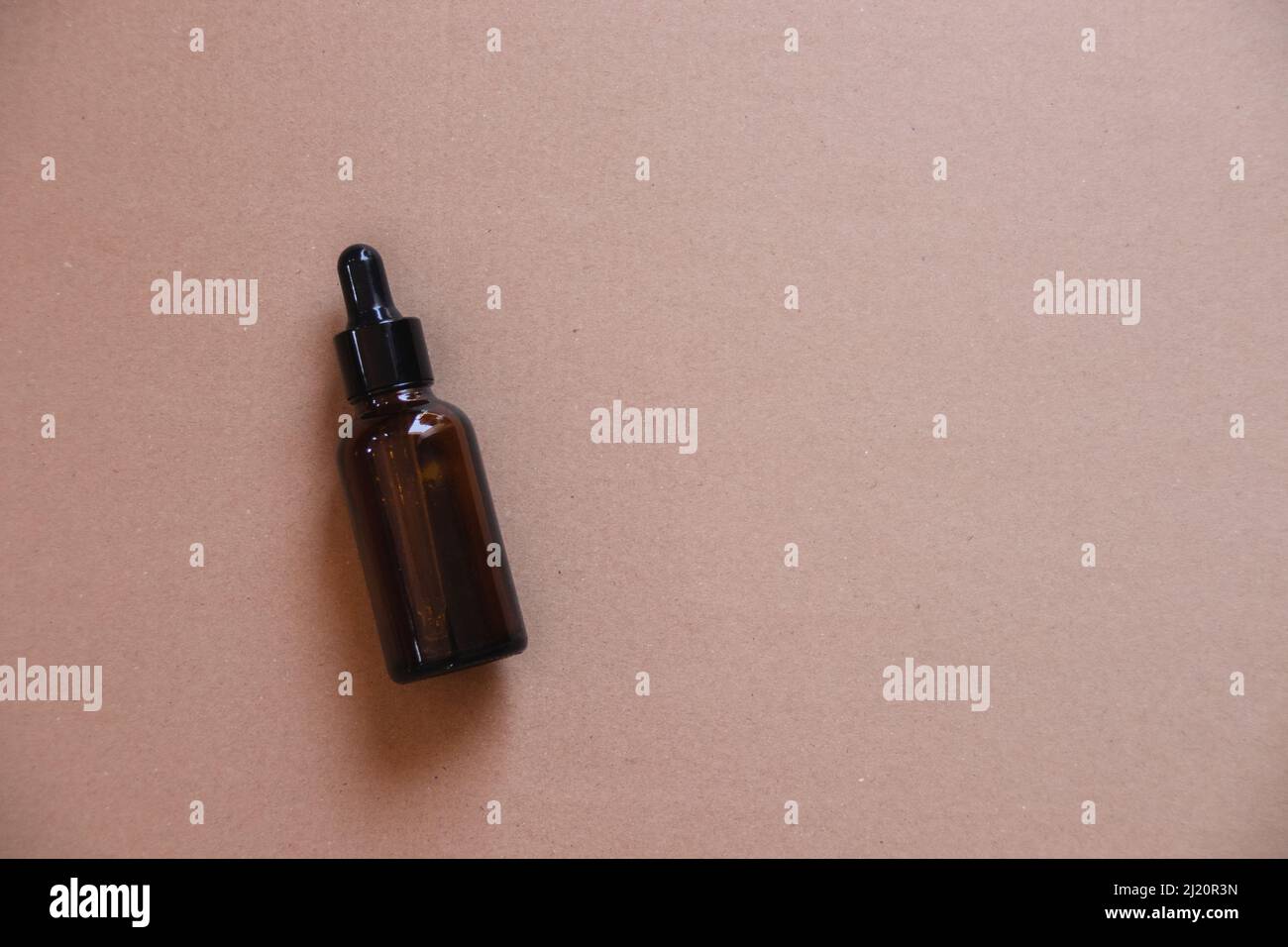 A glass dropper bottle against paper texture background Stock Photo - Alamy