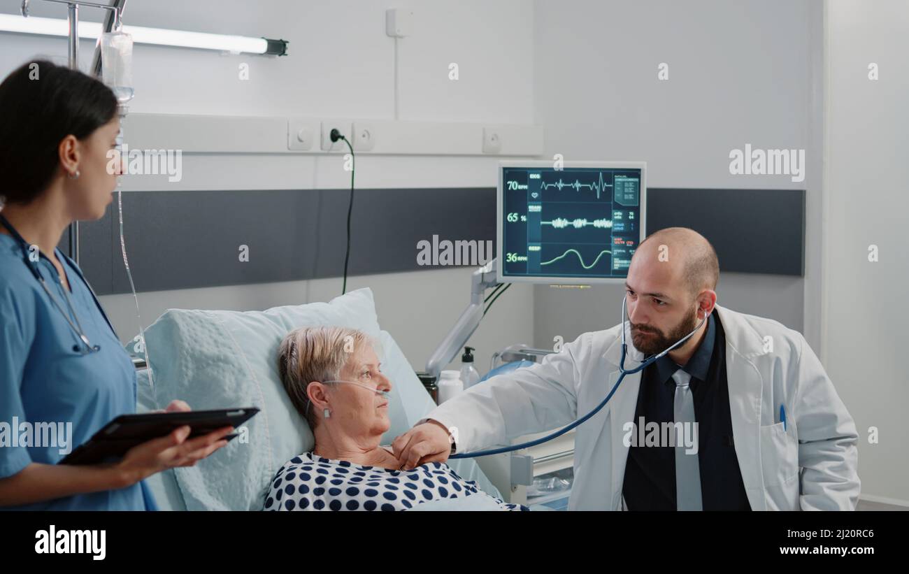 Doctor using stethoscope for heartbeat measurement on sick patient in ...