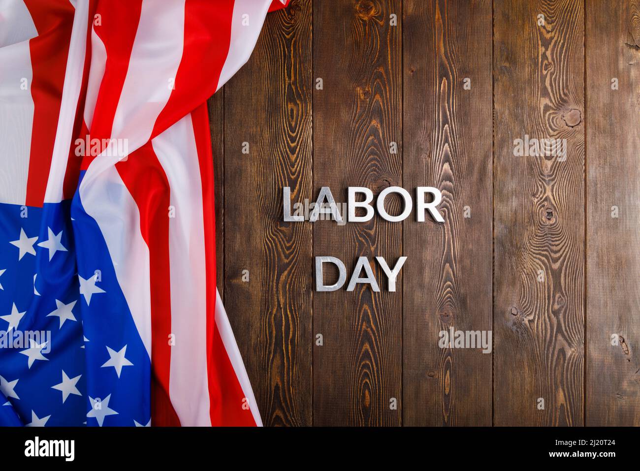 words labor day laid with silver metal letters on wooden surface with ...