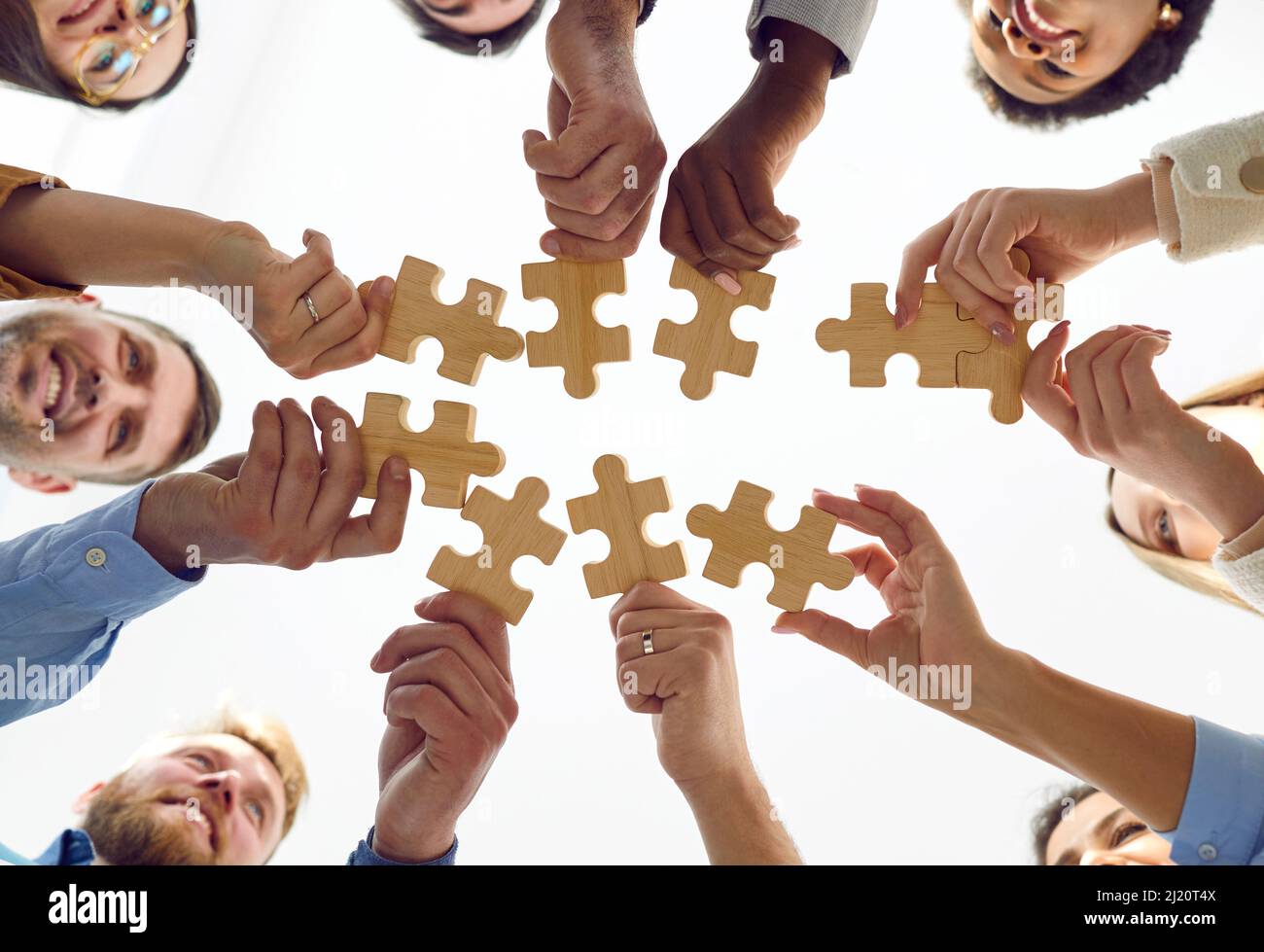 Happy successful business team putting together puzzle pieces during ...
