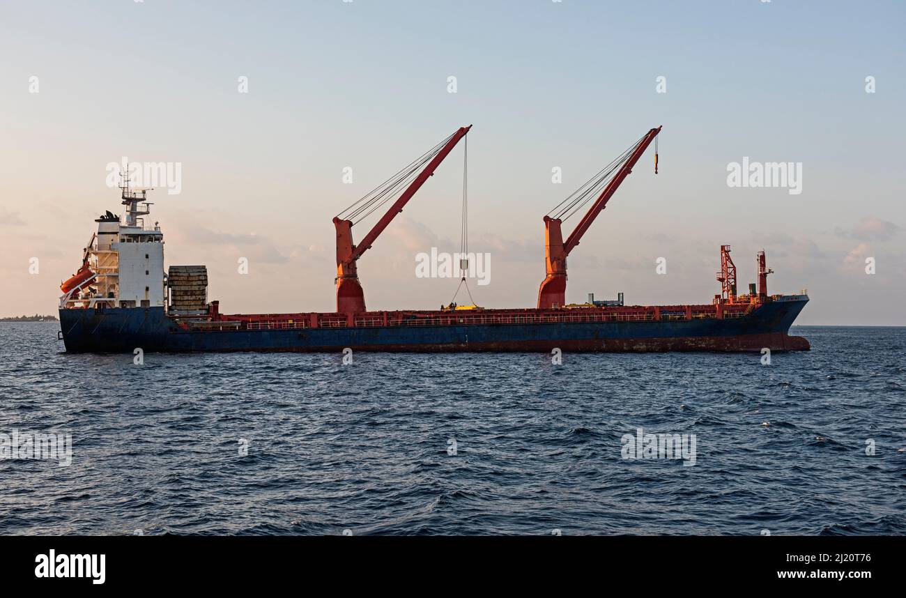 Large cargo container ship at anchor on sea with jib cranes and ...