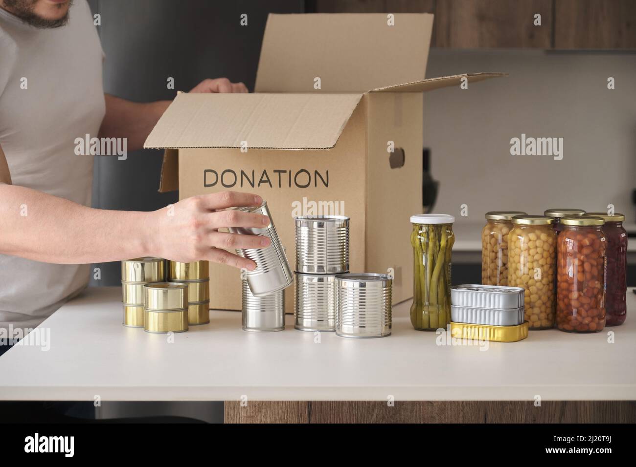 Unrecognizable man filling donation box with non-perishable food Stock ...