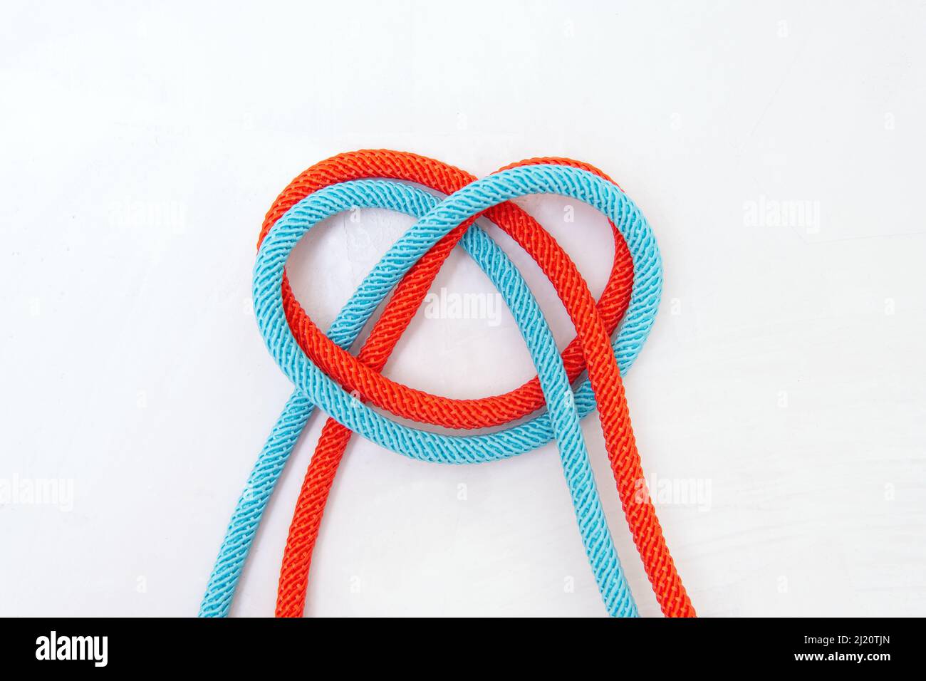 Heart symbol made from two colored cords isolated on gray background ...