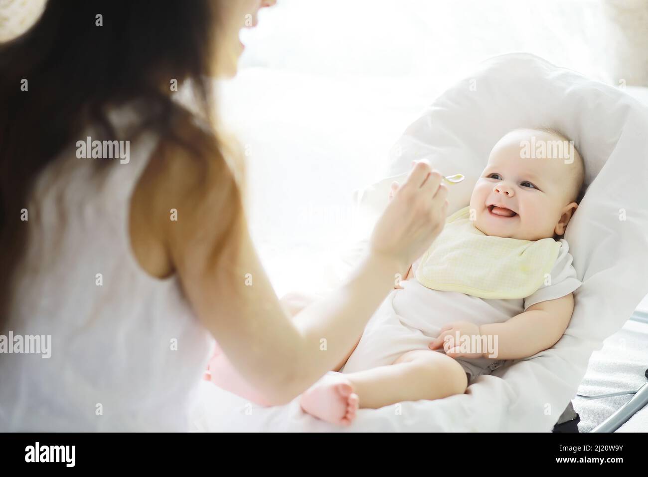 Maternity concept. A young mother feeds her little baby. First lure and ...