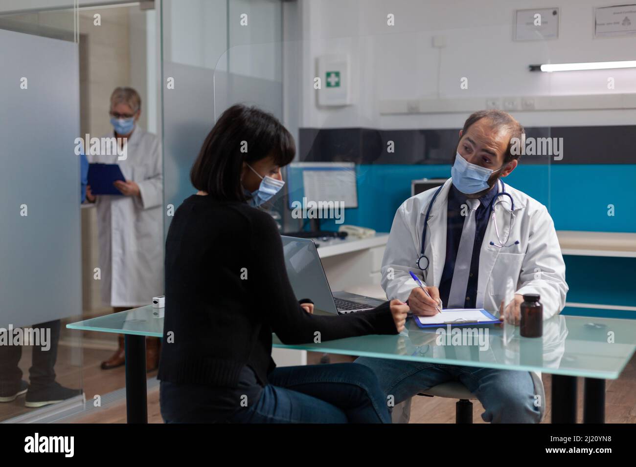 Health physician taking notes at checkup consultation in cabinet, doing ...