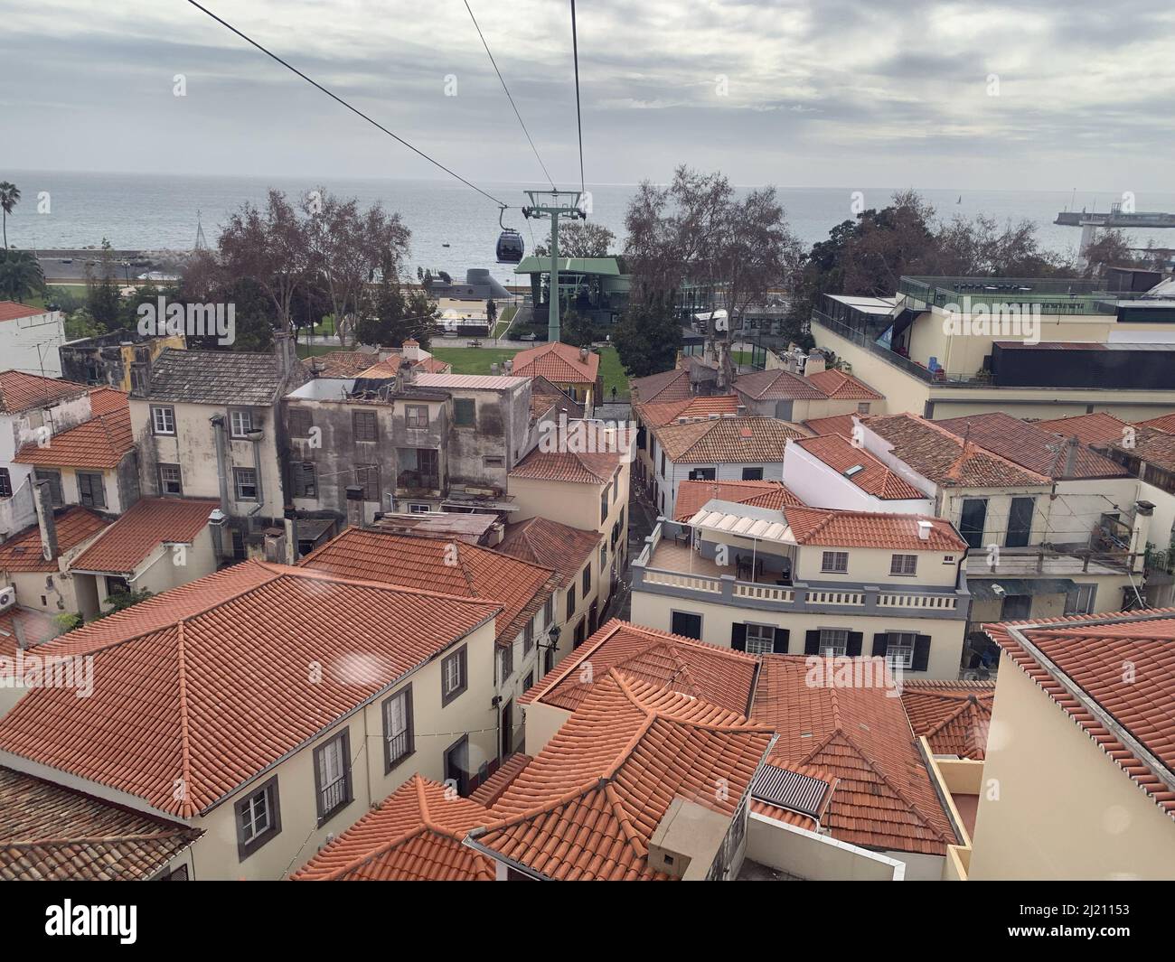 An aerial view of the city with red roof houses and urban cable car ...
