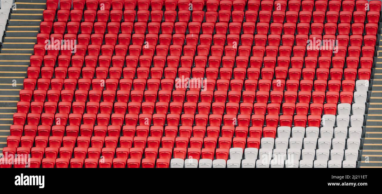 Rows of seats in a football stadium. Bright red and white stadium seats ...