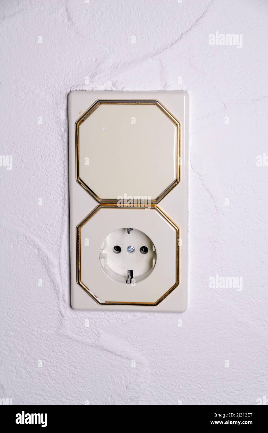 Modern light switch and german power outlet or socket on white wall ...