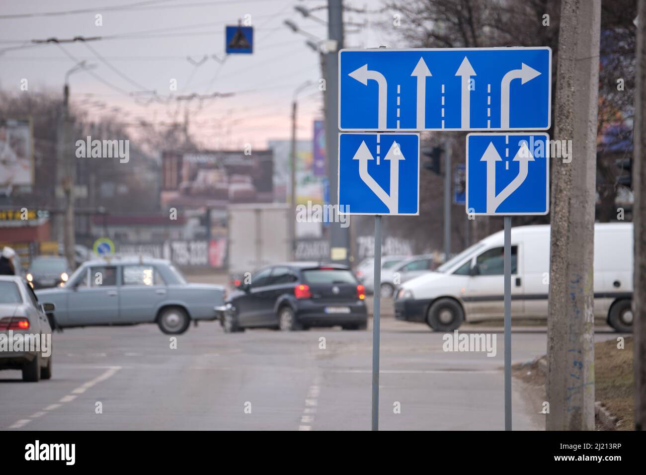 Traffic sign pointing multiple road lanes direction on city street ...