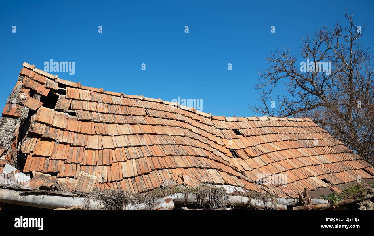 Damaged old tile roof of the house Stock Photo - Alamy