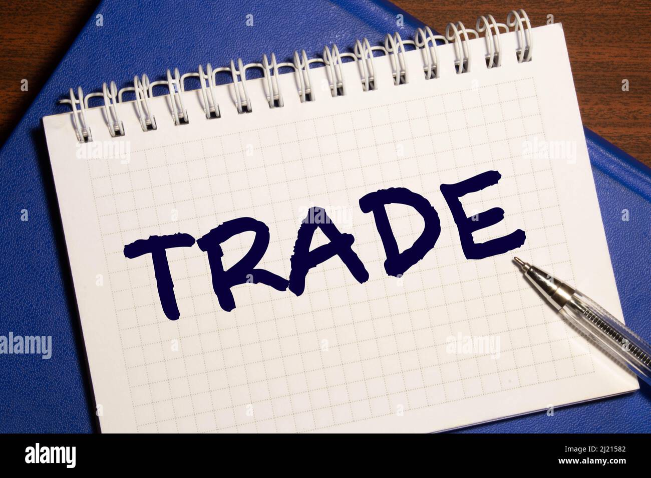 TRADE word on white table through craft torn paper. flat lay, top view ...