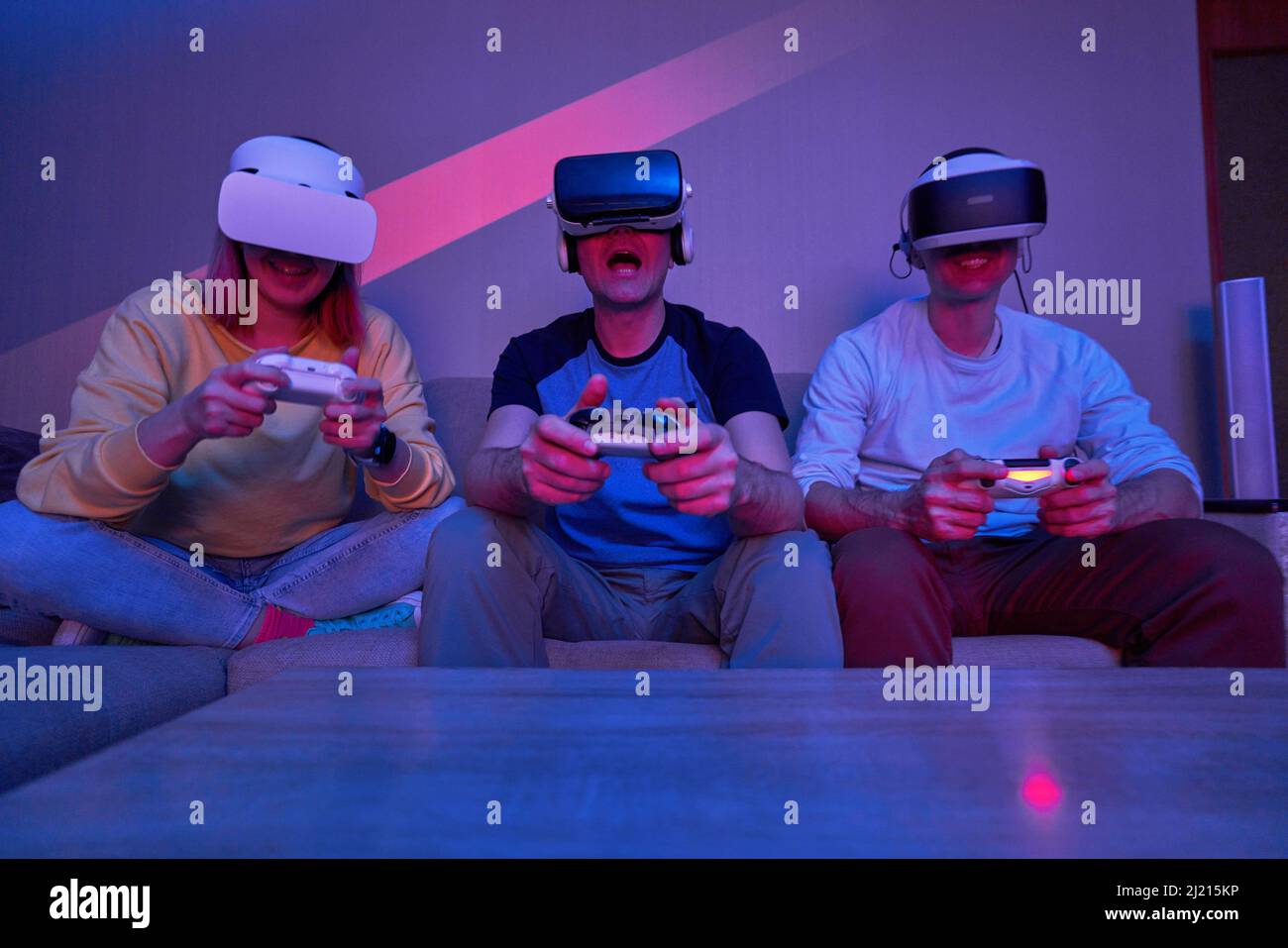 Friends playing virtual reality games using joysticks while sitting on ...
