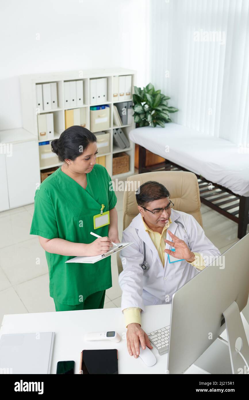 Diverse doctors discussing difficult medical case when looking at ...