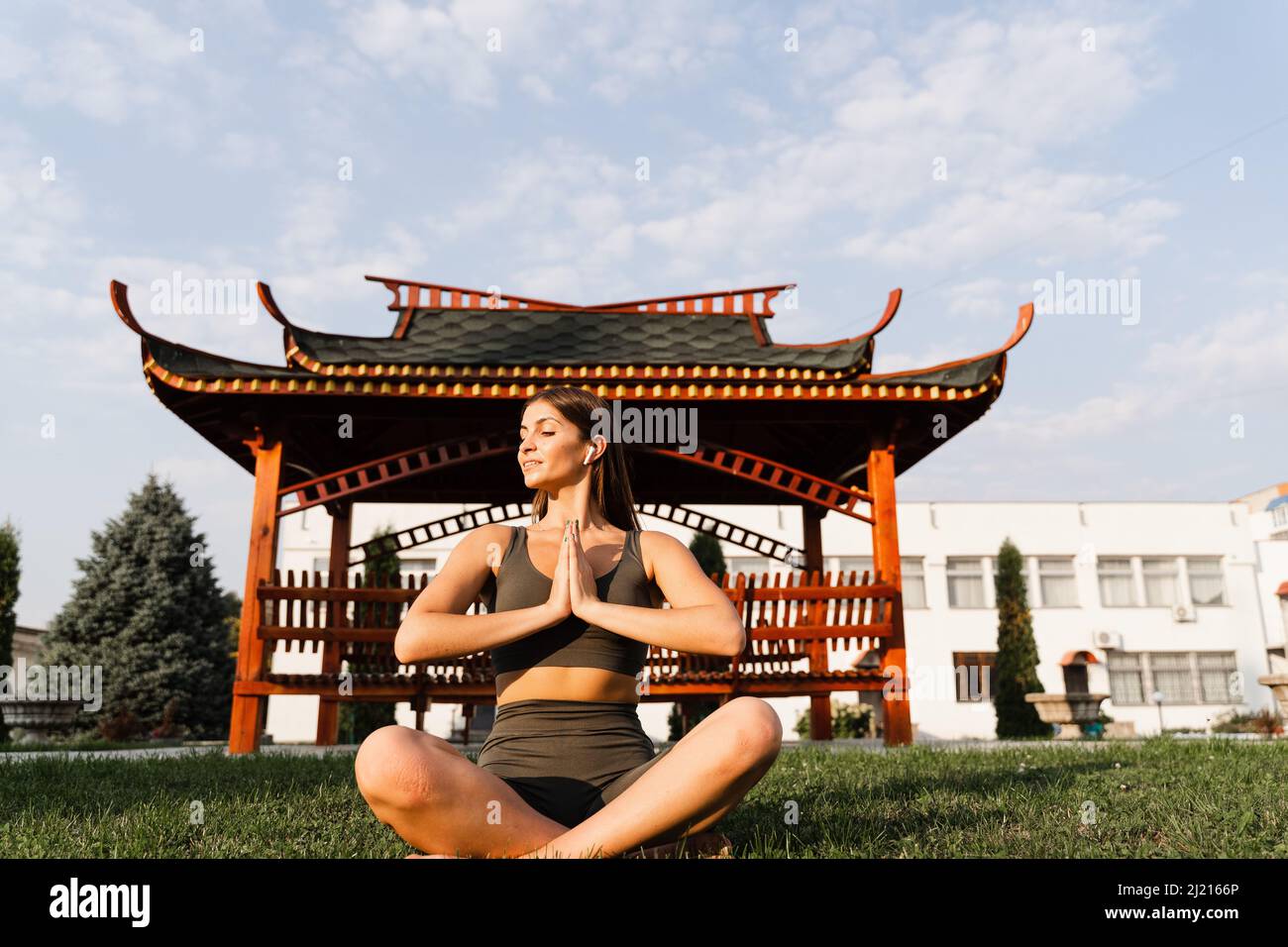 Praying and meditation in lotus position. Fit girl is sitting and ...